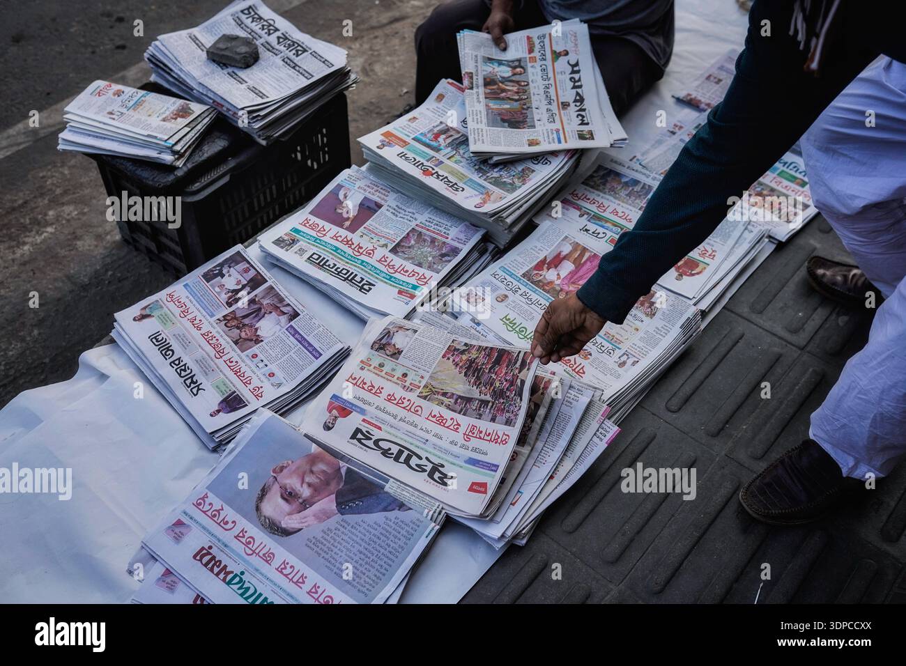 Dhaka, Bangladesh. 13th Feb, 2026. People read newspapers displaying ...
