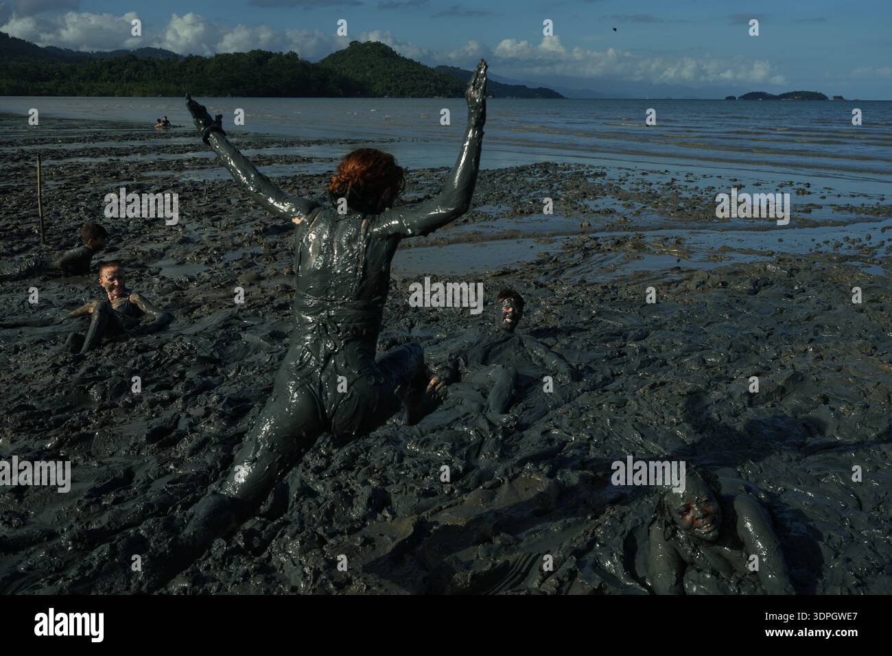 A reveler jumps into a puddle of mud during the Mud Block carnival ...