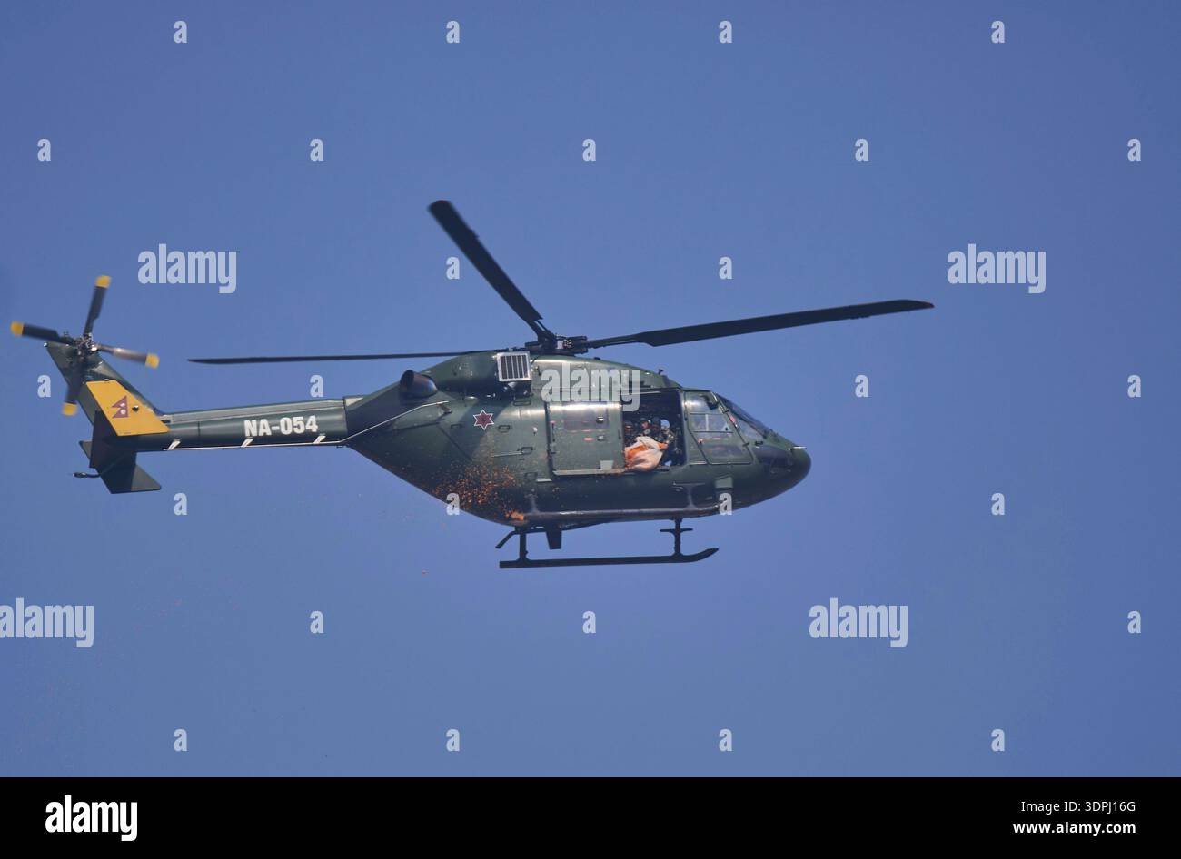 Personnel from the Nepalese Army shower flowers from a helicopter over ...
