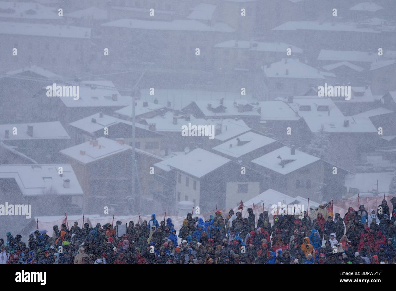 Spectators stand under a snowfall as they watch an alpine ski, men's ...