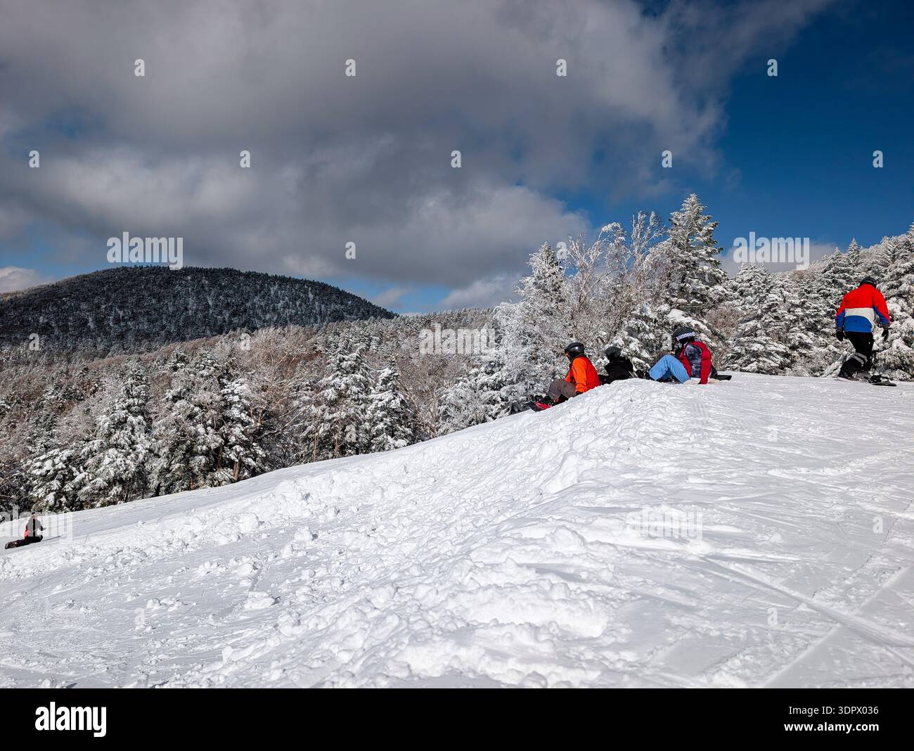Snowboarders resting on the snowy slopes of Yokoteyama Ski Resort in ...