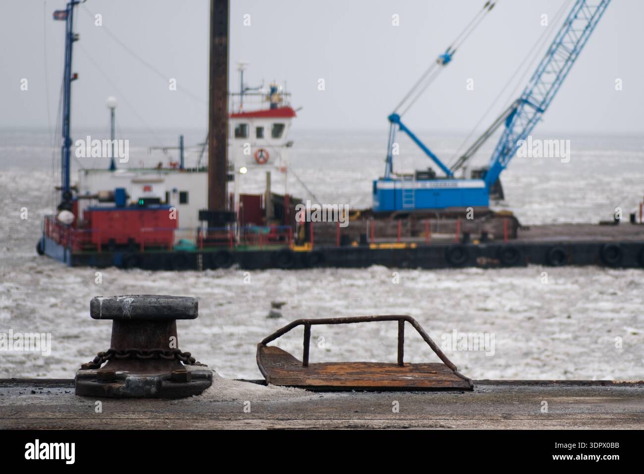 Work vessel with crane operating in the North Sea harbor near Cuxhaven ...