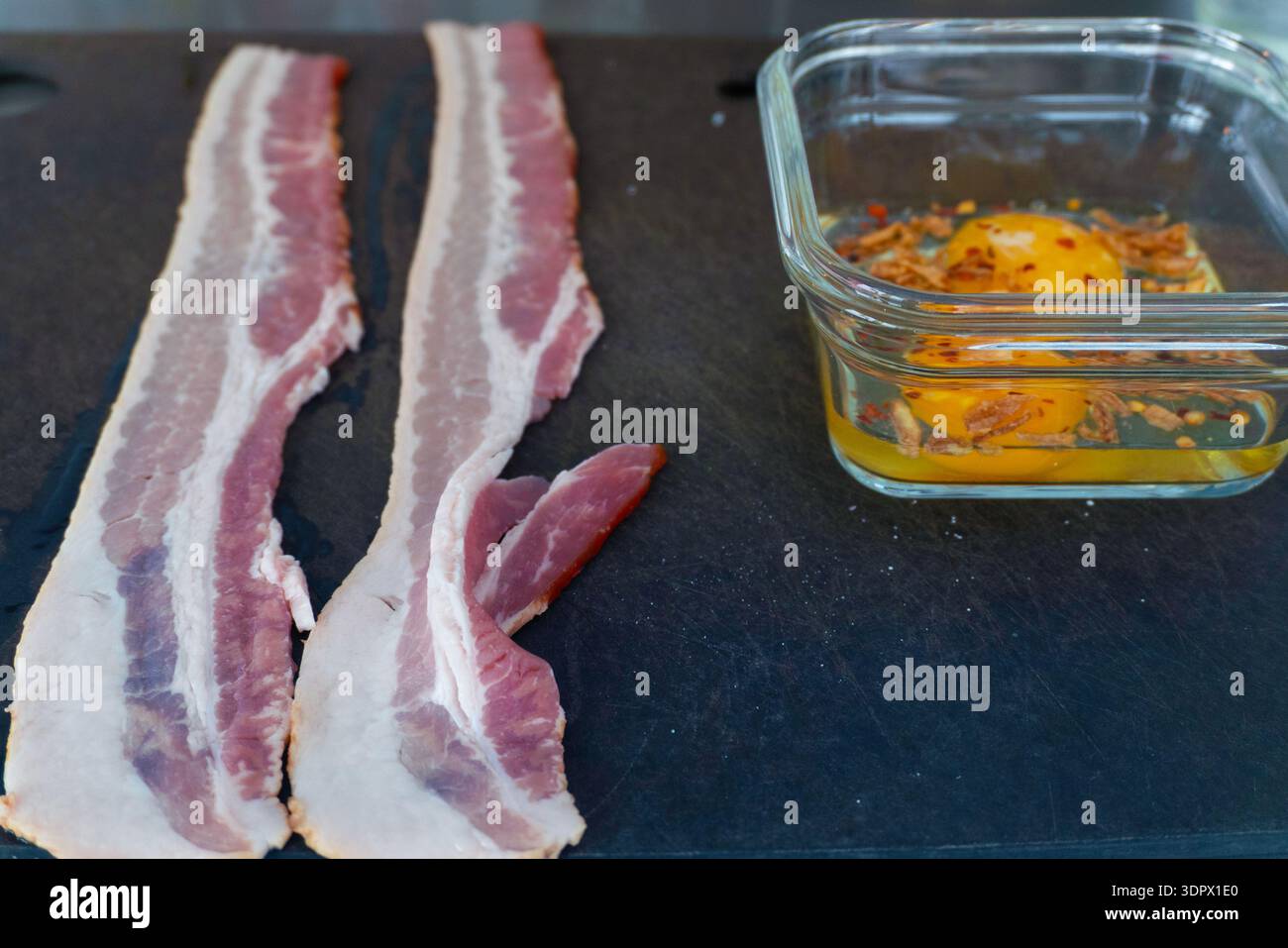 Grilled bacon marinating in soy sauce with garlic and herbs in glass ...