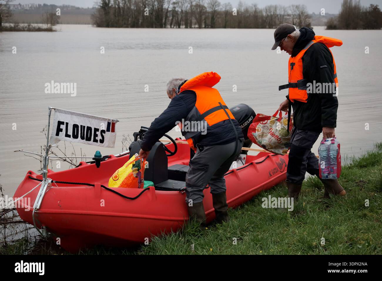People load food in a boat in Loubes, western France amid storm Nils ...