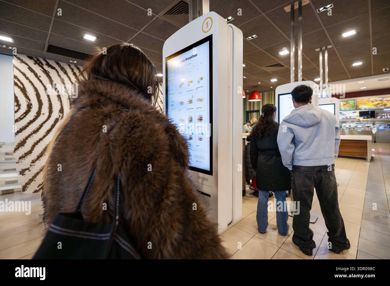 Customers using digital ordering kiosks inside a McDonald s restaurant ...