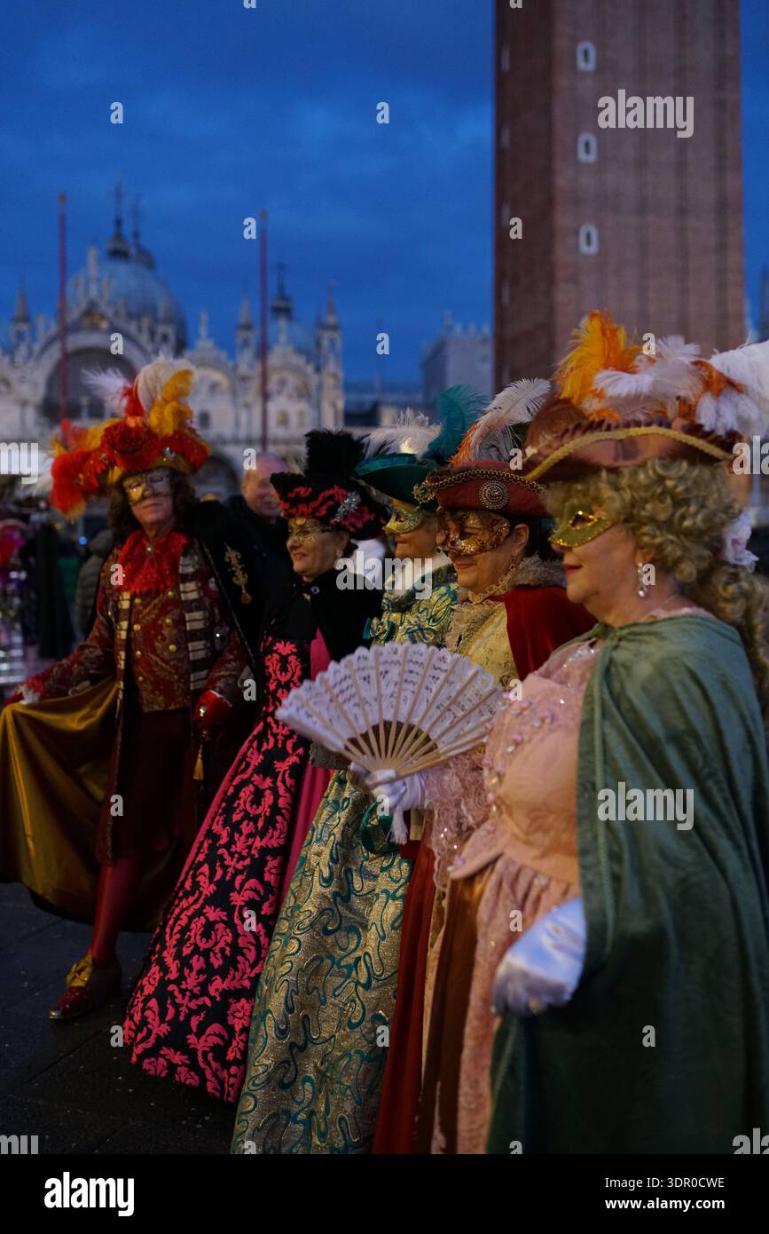 Masked revellers pose for a portrait at dawn in St. Mark's Square ...