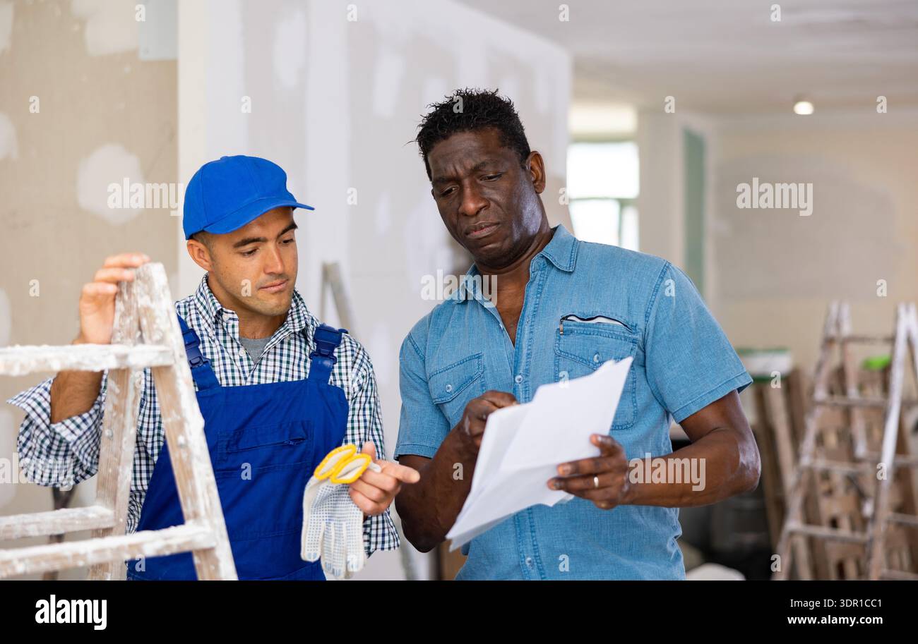 Employer and builder discussing project documentation in construction ...