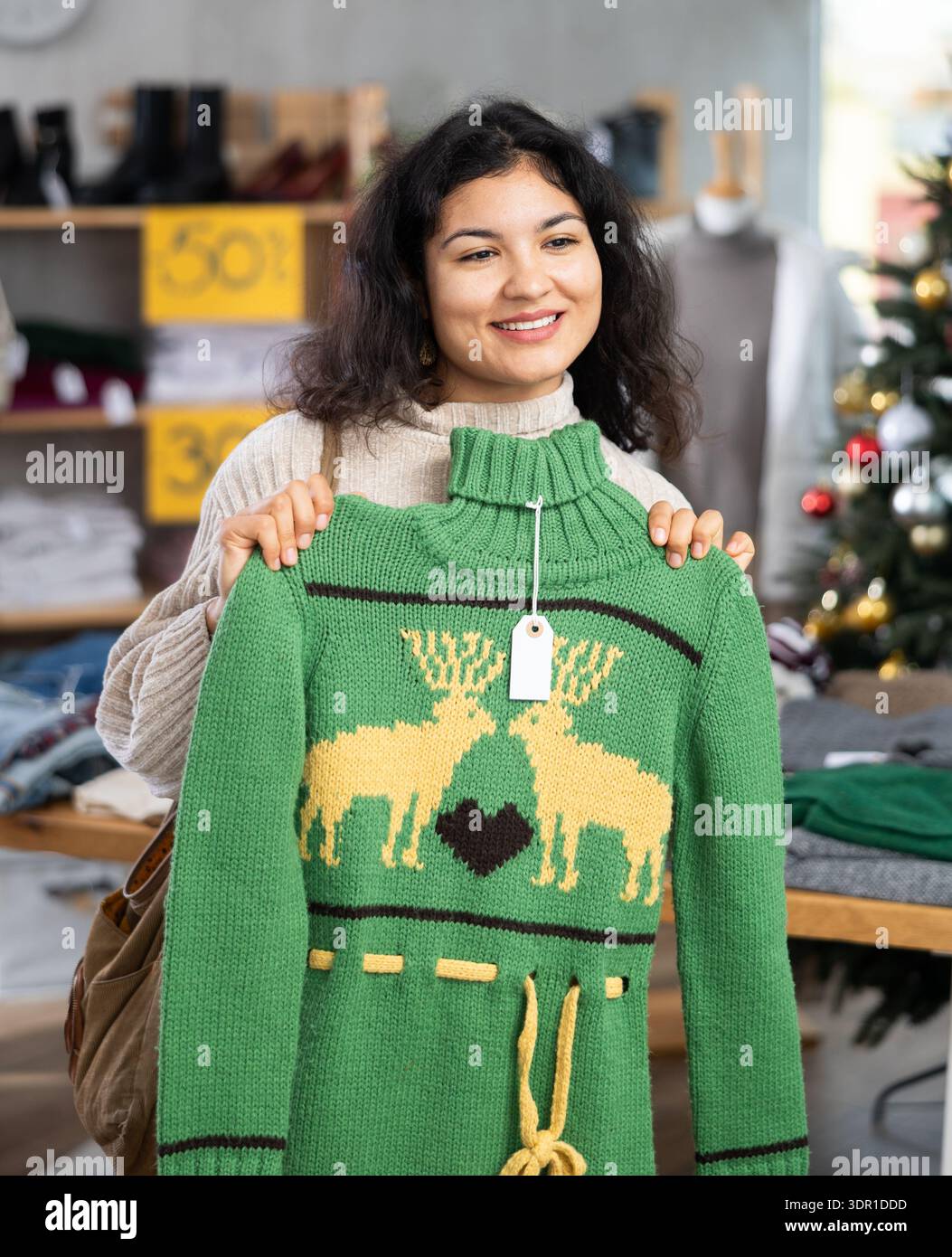 Latina woman chooses fashionable sweater in clothing store Stock Photo ...