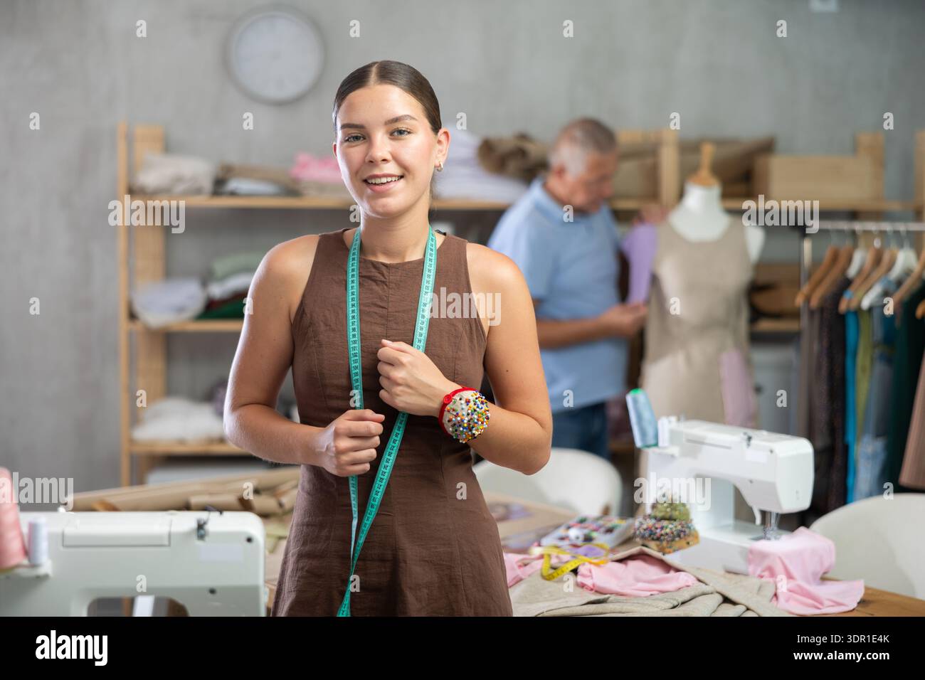 Girl fashion designer is in office, senior man tailor apprentice work ...