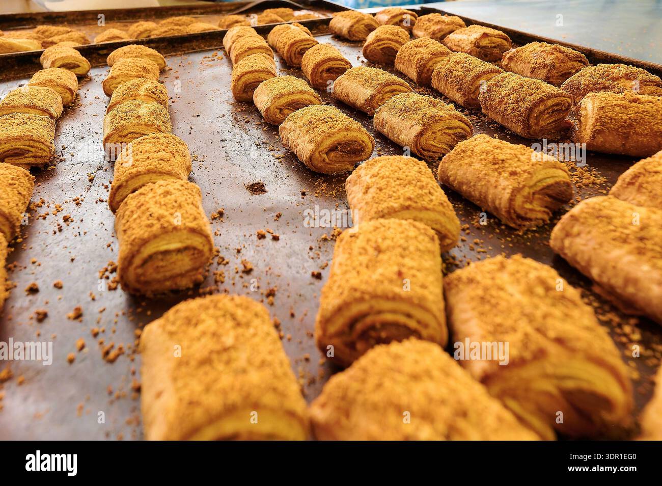 Freshly baked rolled pastries with sweet filling on a tray in a bakery ...