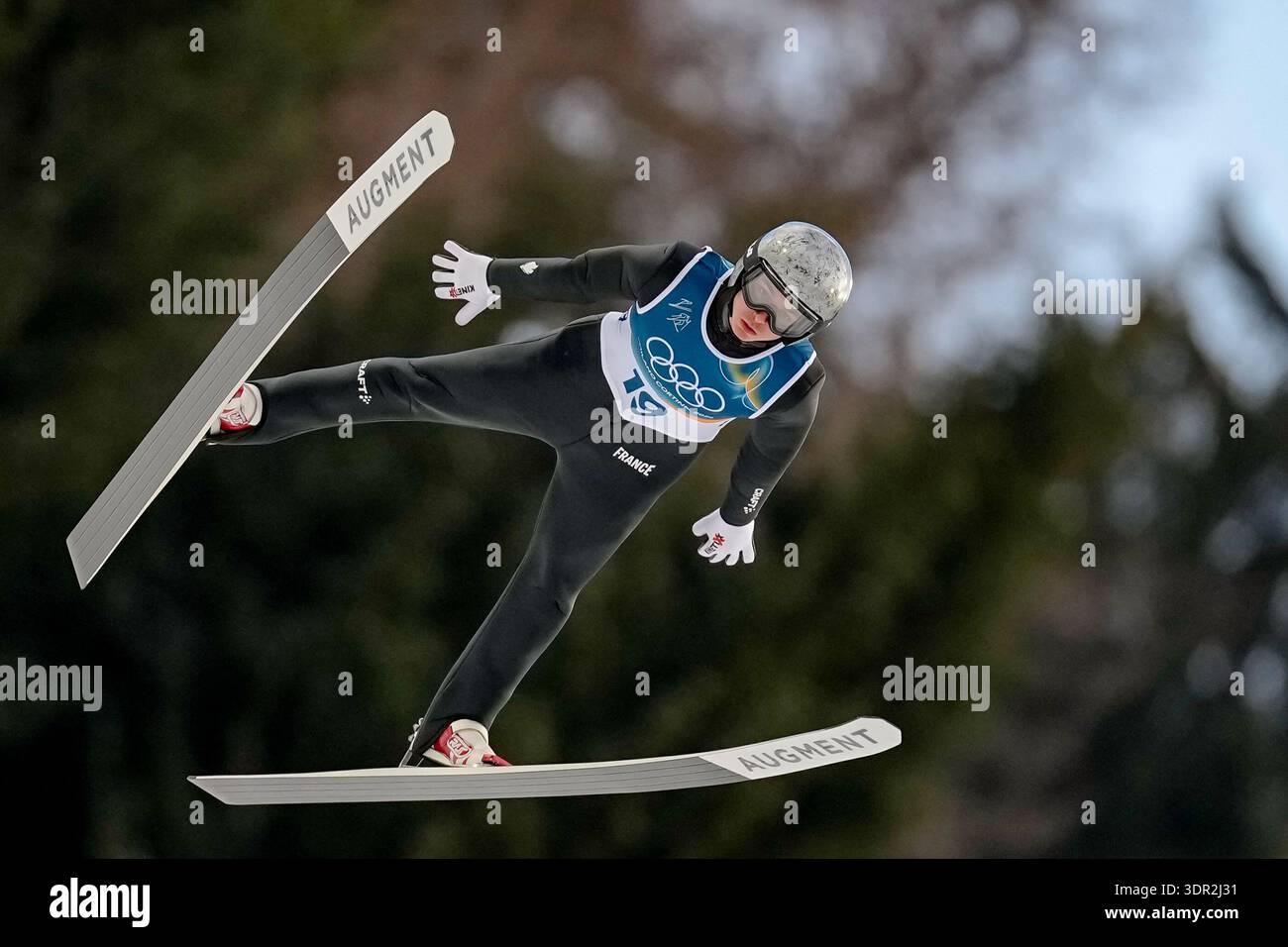 Marco Heinis, of France, soars through the air during his trial jump of ...