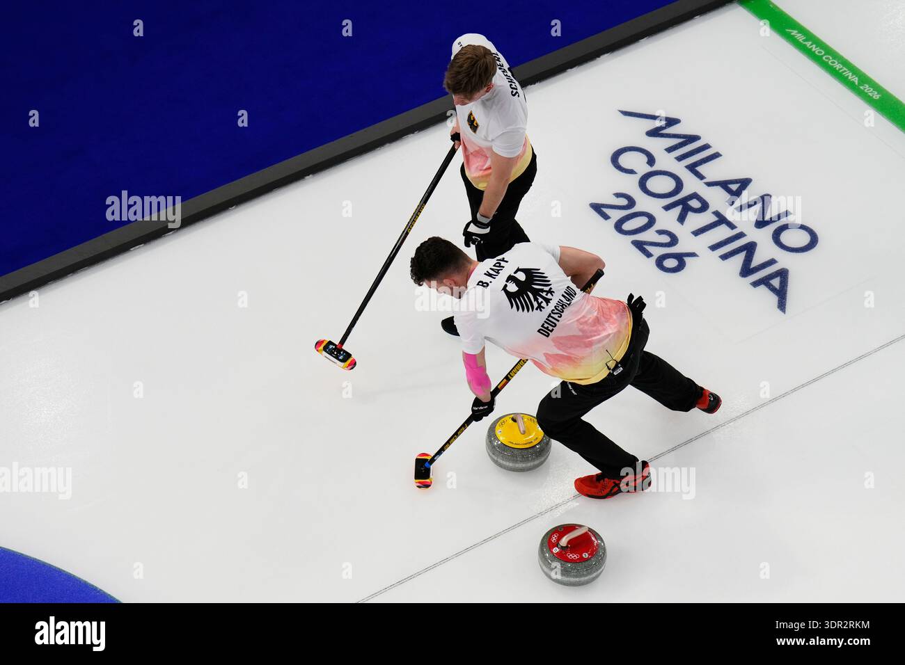 Germany's Johannes Scheuerl and Benjamin Kapp sweep ahead of a stone ...