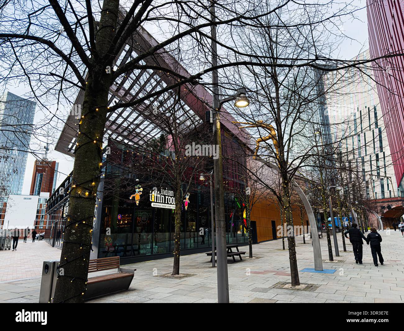 Manchester, UK - January 24, 2026: Pedestrians stroll past a glass ...