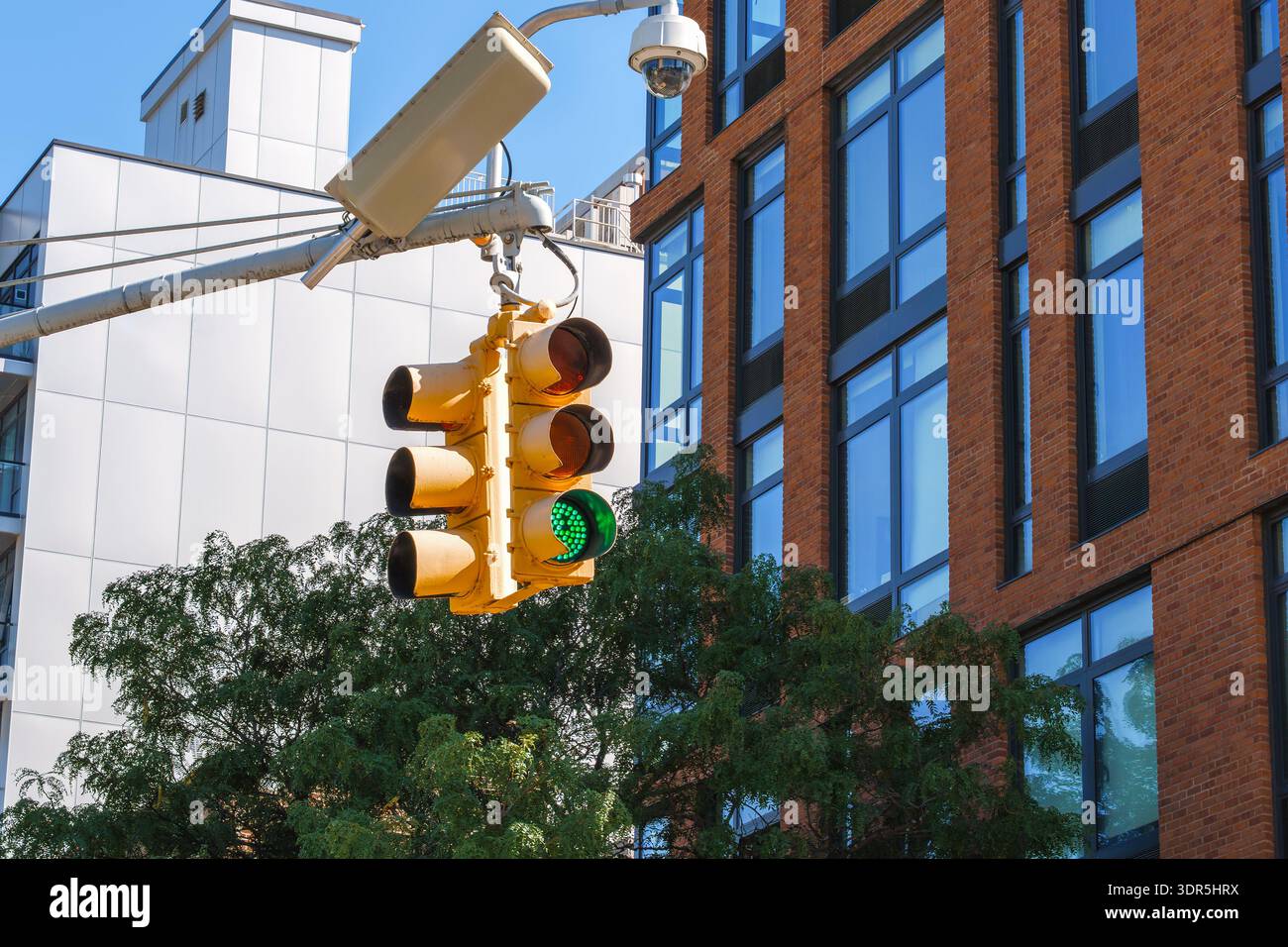 Yellow traffic signal hangs above a New York City intersection with ...