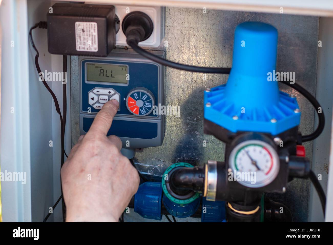 A man hand presses a button on a digital pump controller with a ...