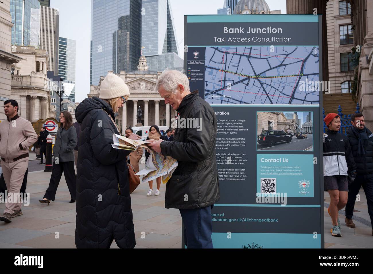 A couple consult a paper map at the corner of Mansion House, Walbrook ...