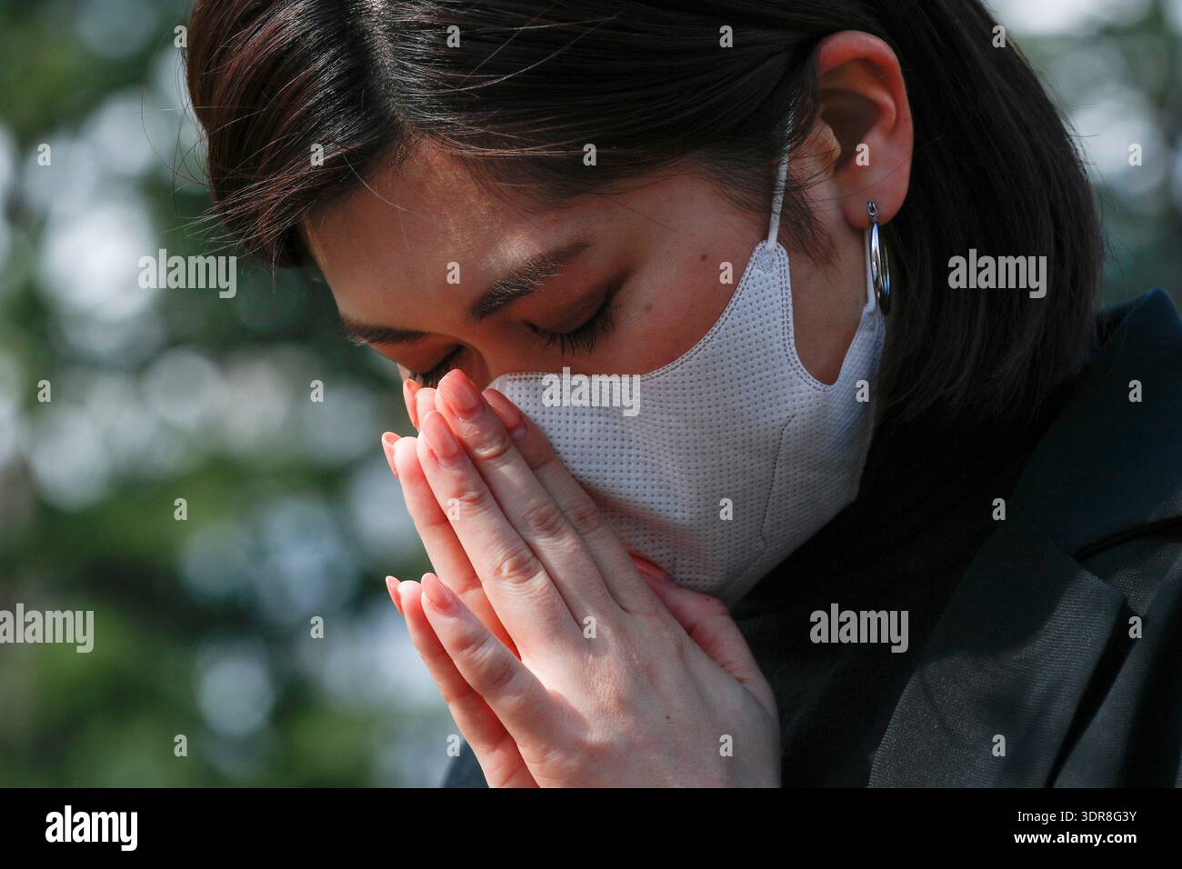 March 11, 2020, Tokyo, Japan: A woman wearing a face mask prays during ...