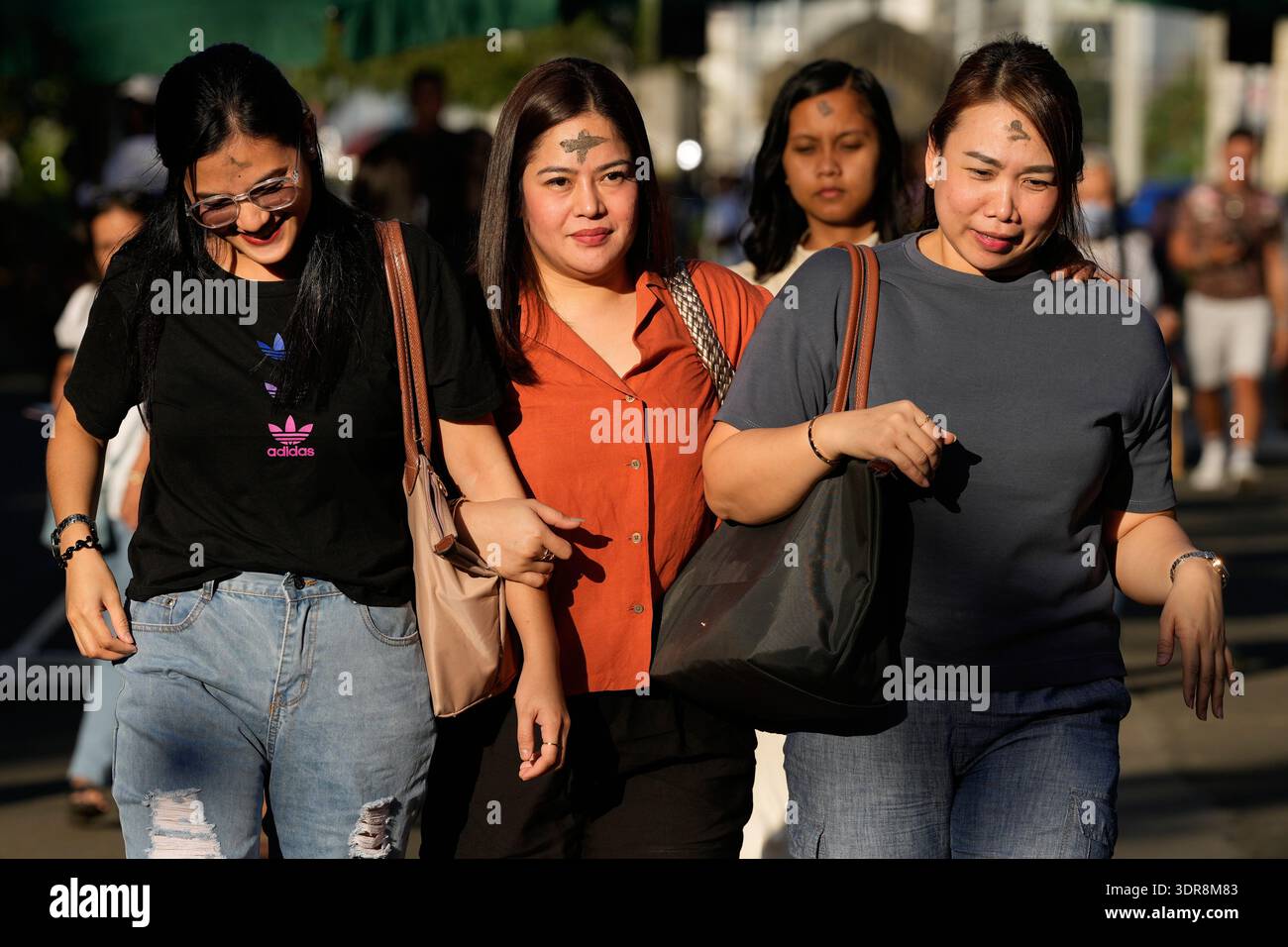 Devotees with an ash cross on their forehead walk during Ash Wednesday ...