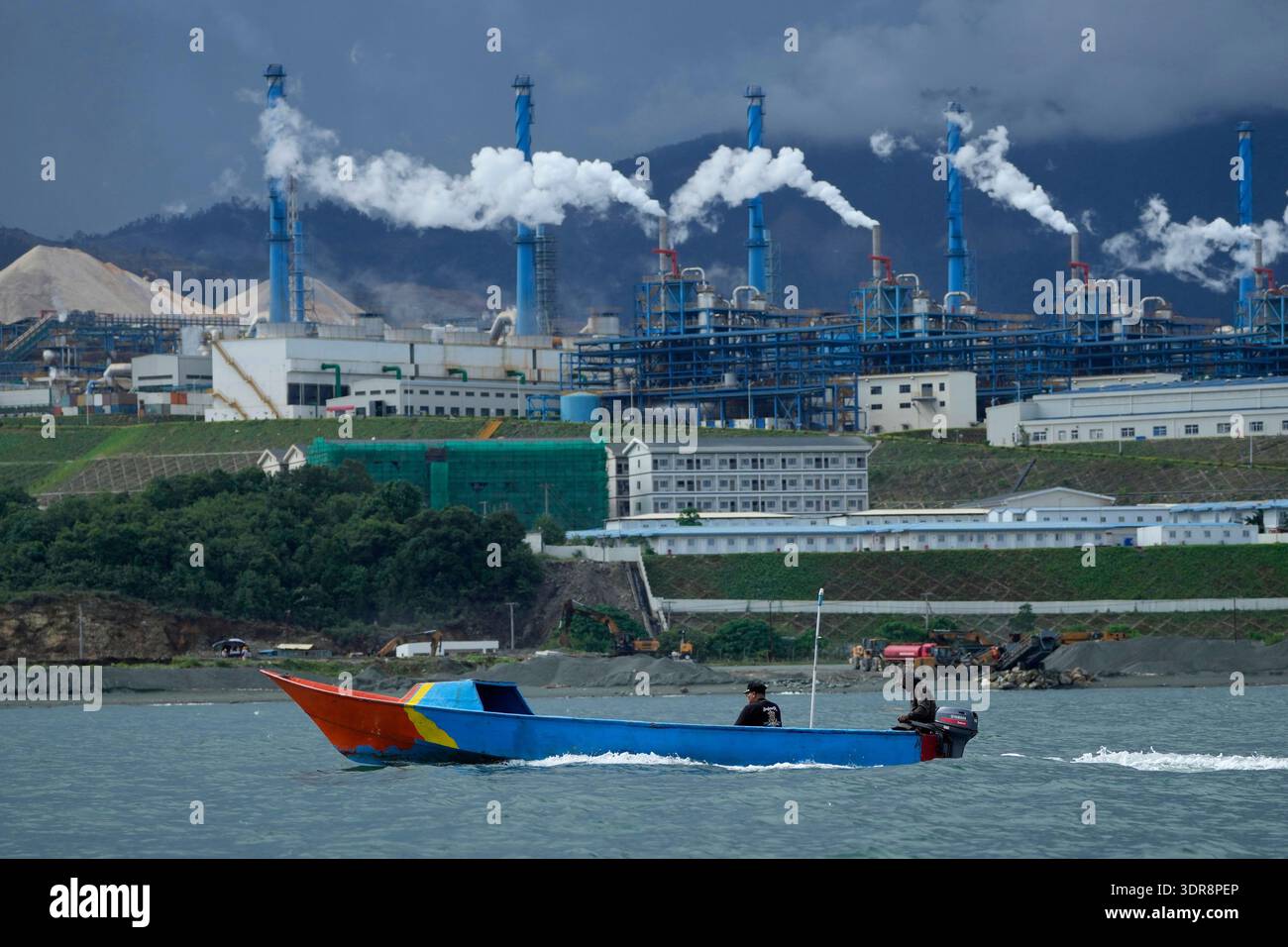 FILE - A boat cruises past a nickel processing plant at Indonesia Weda ...