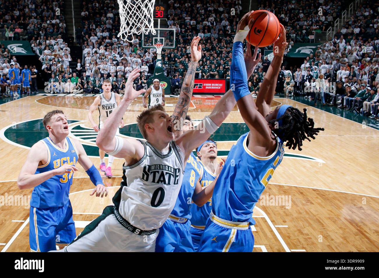 Michigan State forward Jaxon Kohler (0), center, and UCLA center Steven ...