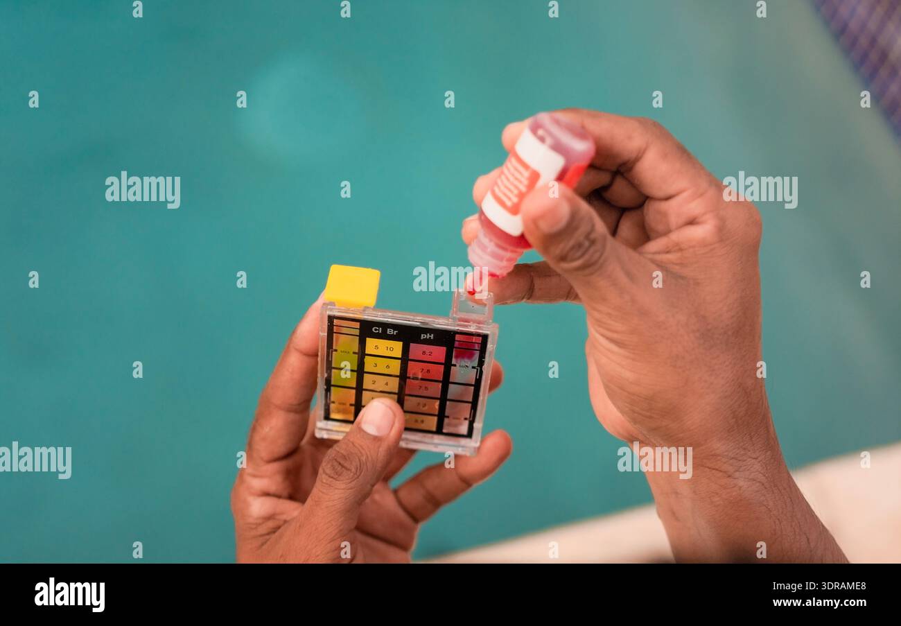 Testing the chlorine and PH of swimming pool. Close up of person ...
