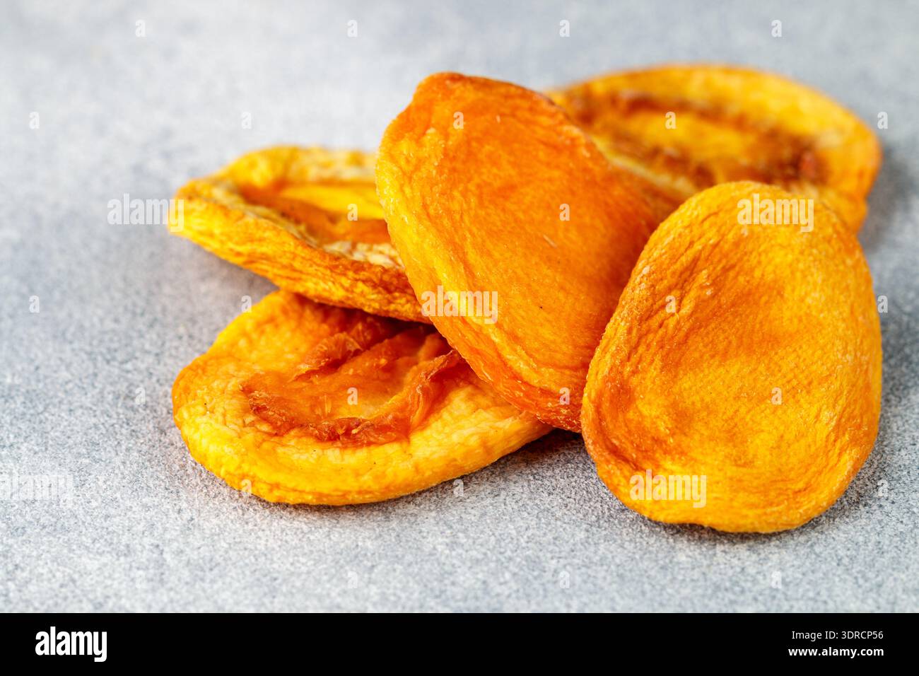 Dried delicious peaches on a gray concrete or stone background. An ...