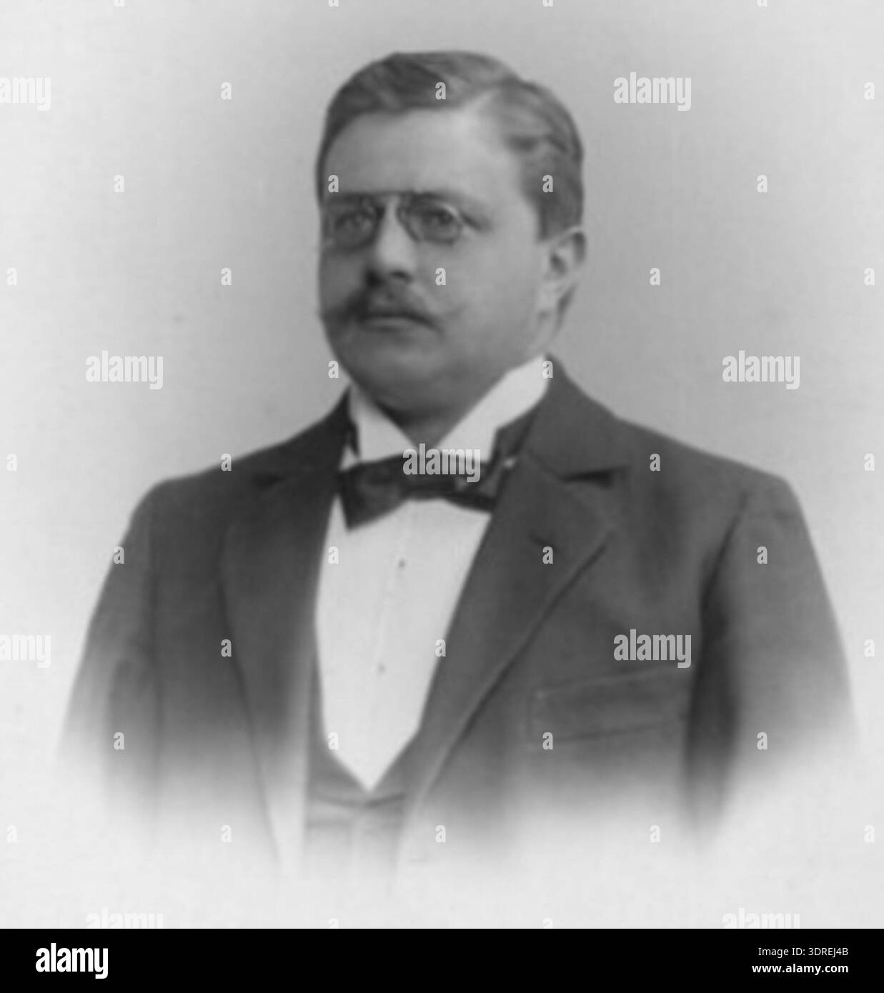 Seated with composed posture the photograph shows his facial features ...