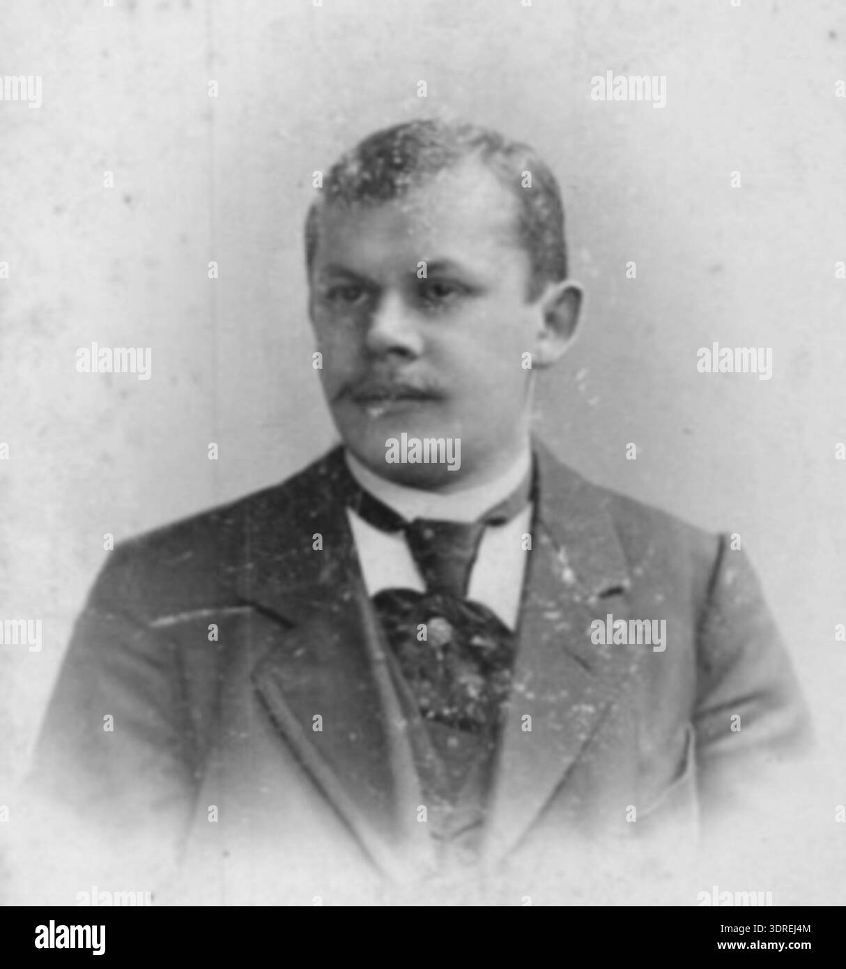 Seated with composed posture the photograph shows his facial features ...