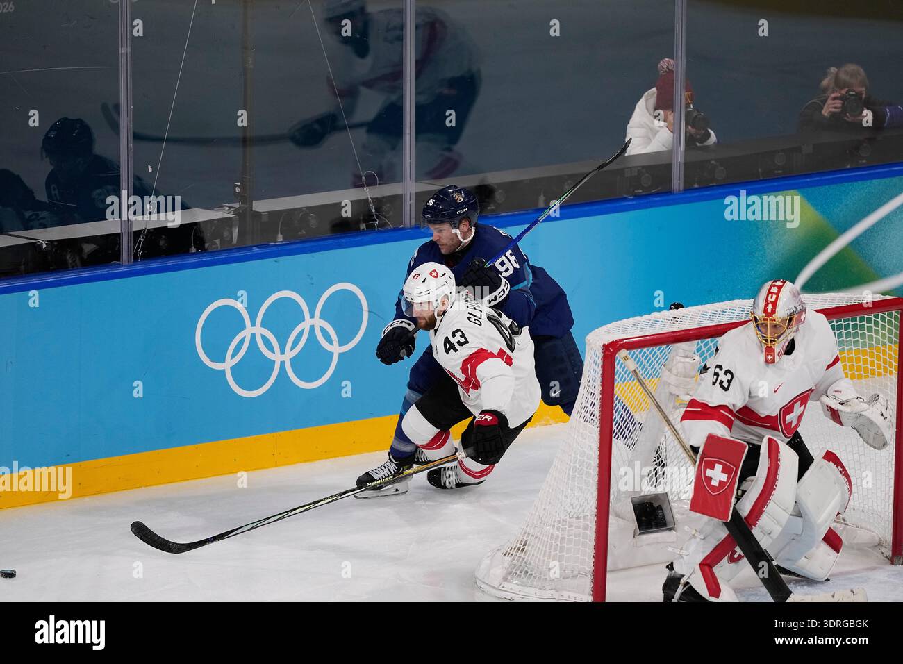 Switzerland's Andrea Glauser (43) challenges for the puck Finland's ...