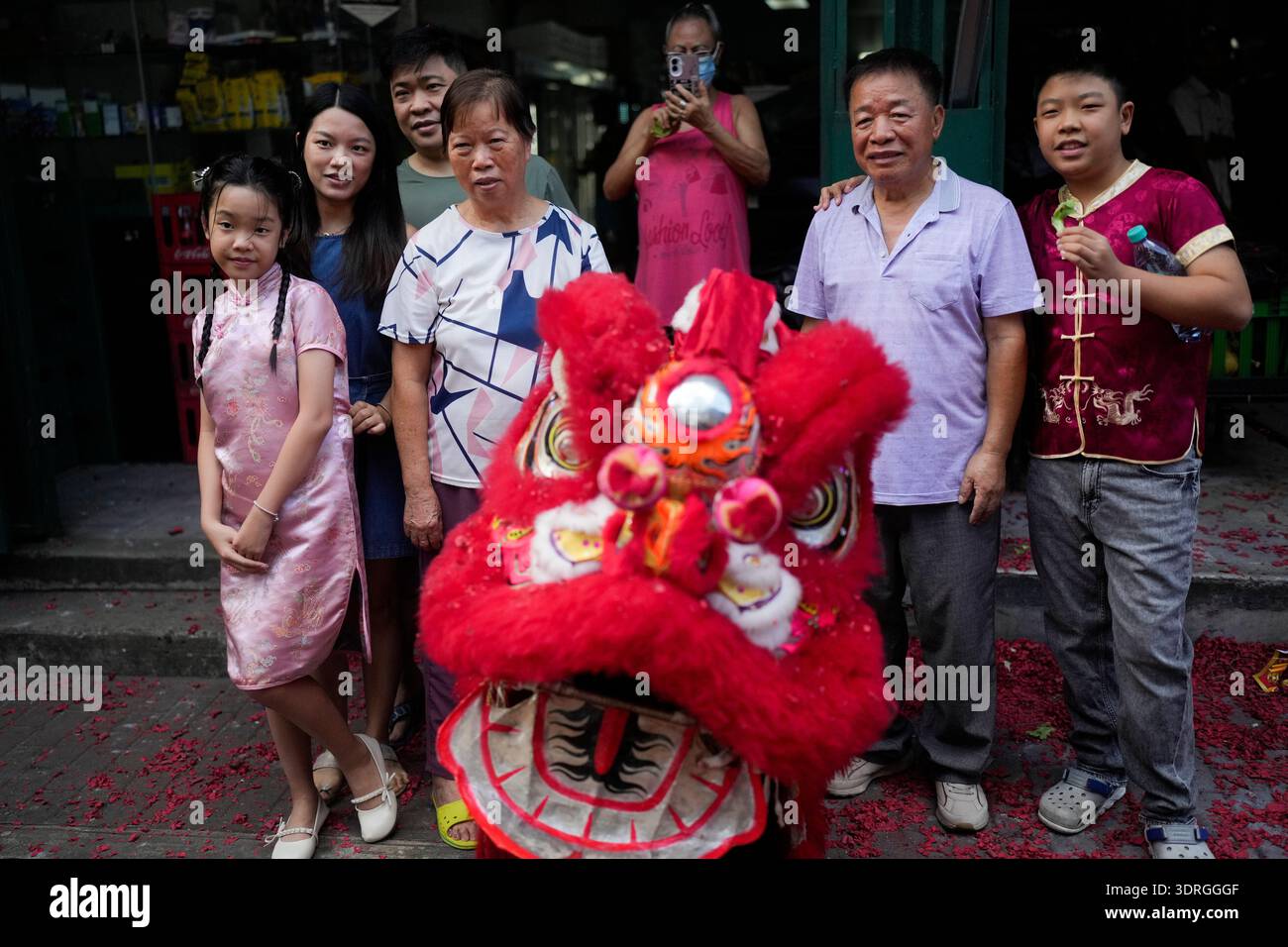 A family poses with lion-costumed performers during Lunar New Year ...