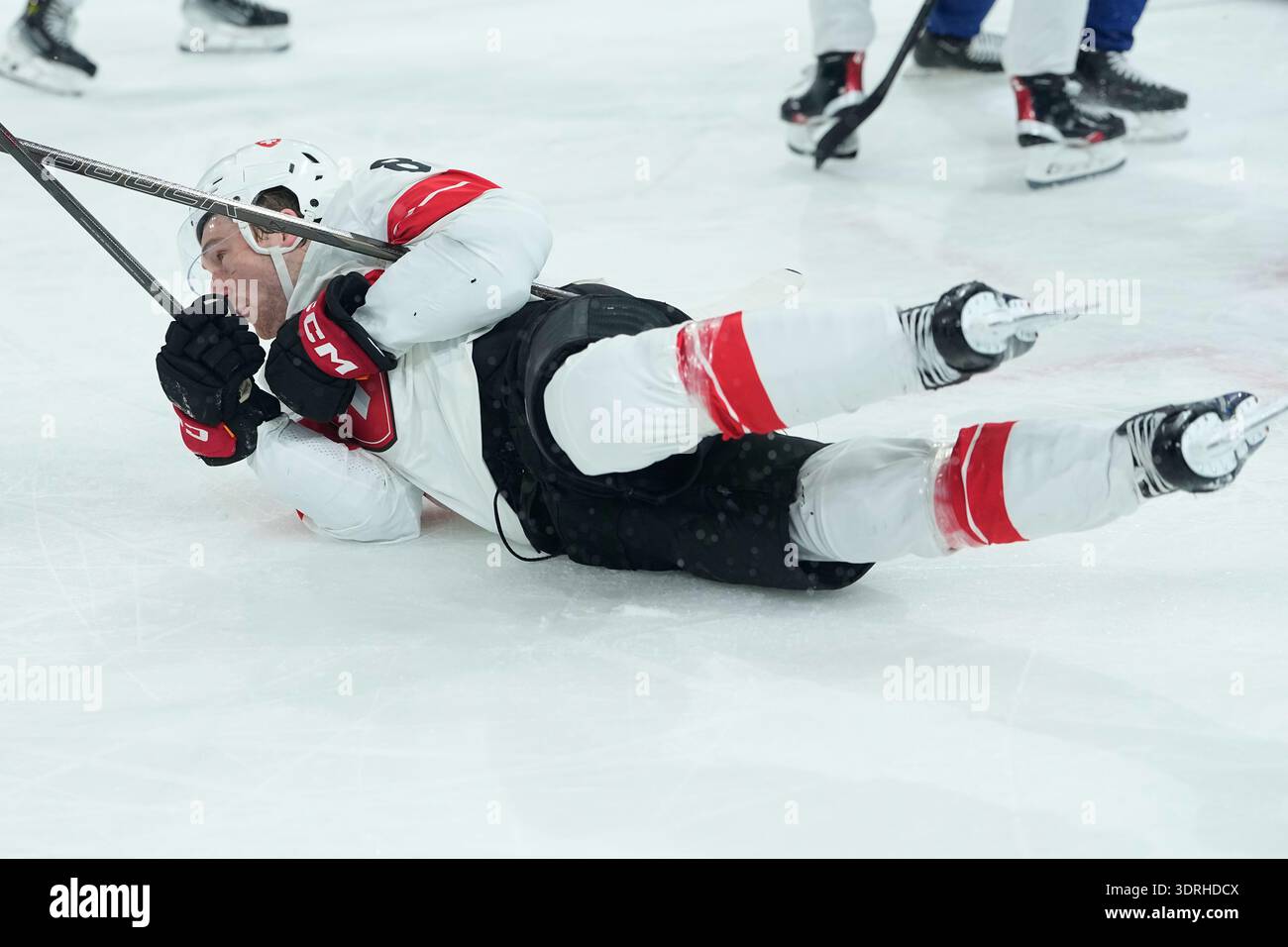 Switzerland's Simon Knak (8) falls during a men's ice hockey ...