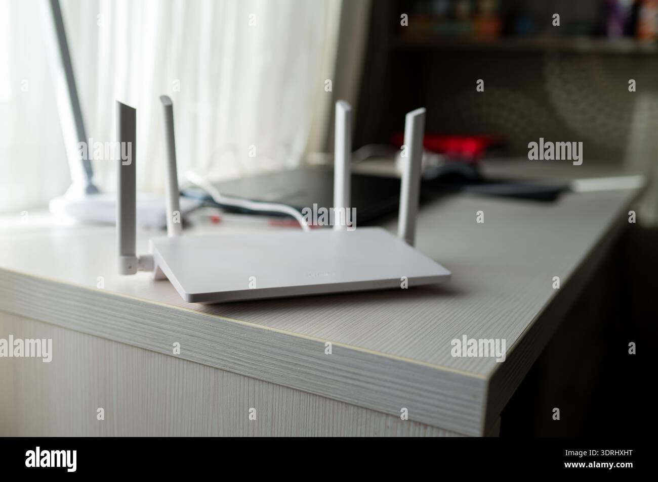 A high-speed wireless internet router stands on a white wooden table ...