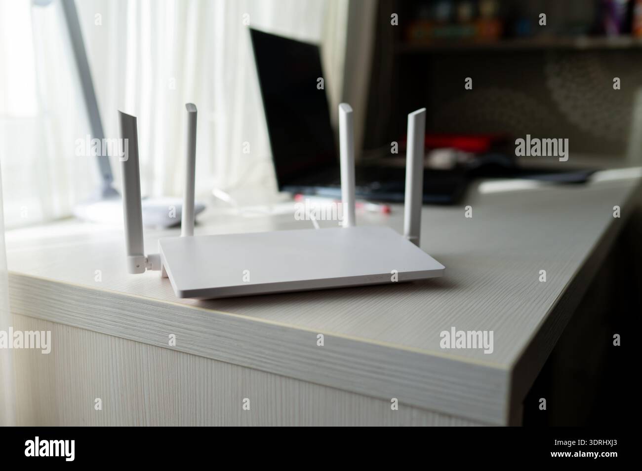 A high-speed wireless internet router stands on a white wooden table ...