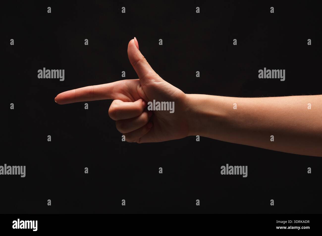 Hand Gesture Forming a Shape That Resembles a Gun in a Dark Setting ...