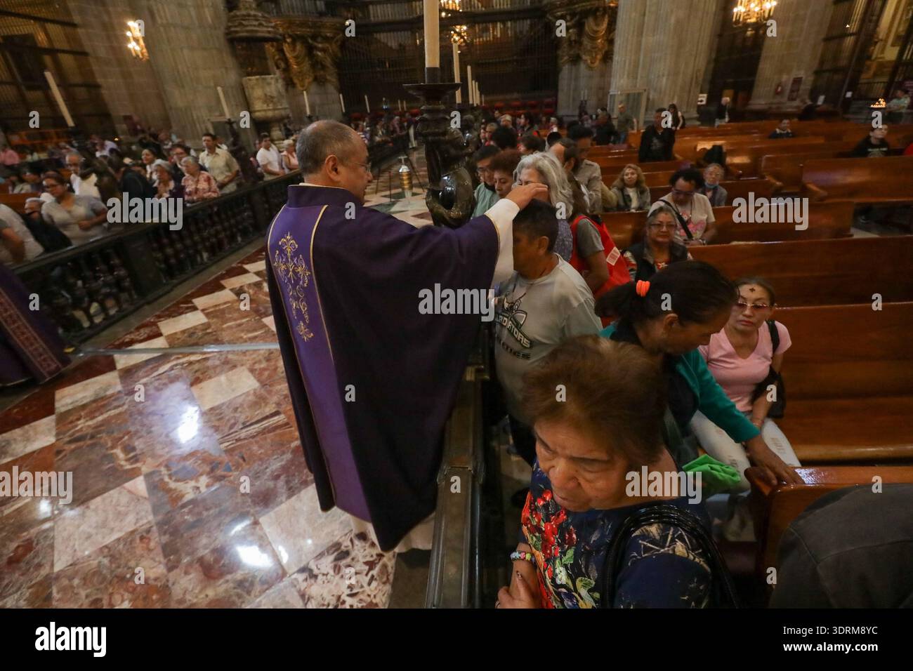 A priest from the Archdiocese of Mexico City puts ashes on the forehead ...