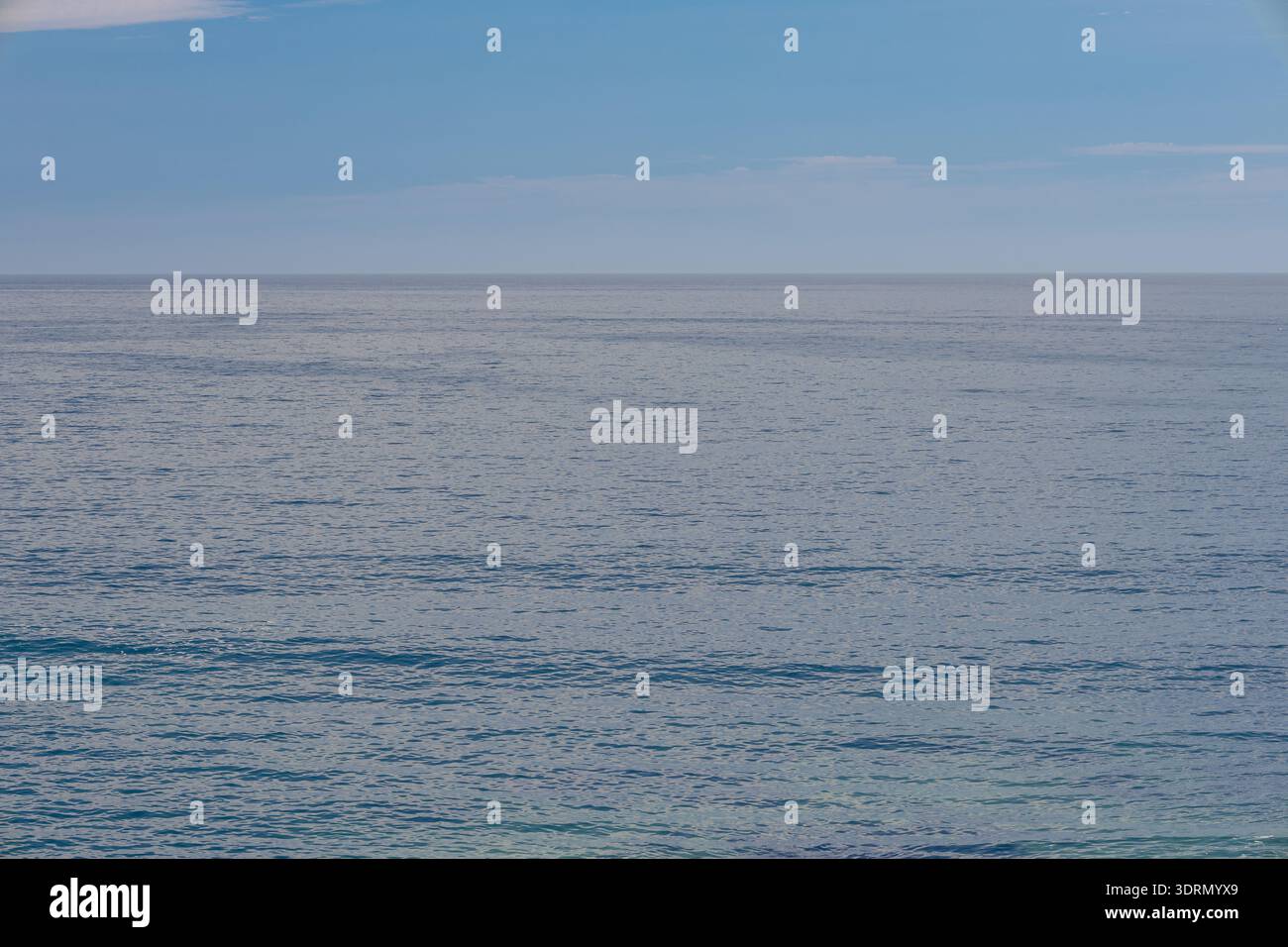 Wide-angle minimalist composition of a calm sea horizon under a clear ...