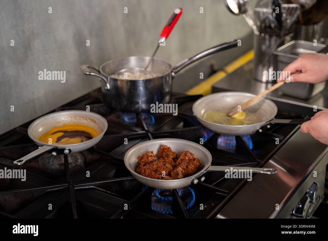 View of multiple pans cooking on gas stove in kitchen Stock Photo - Alamy