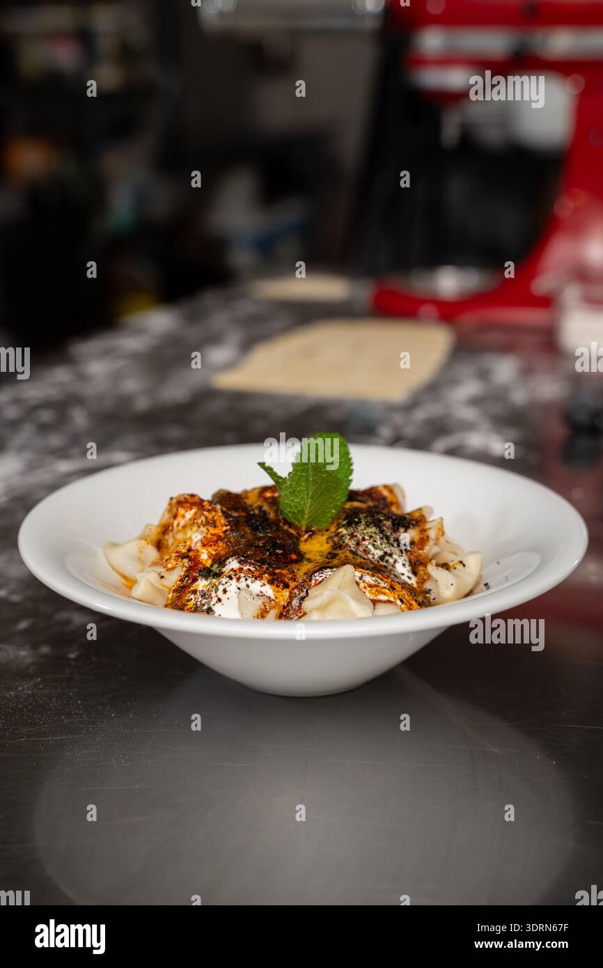 Turkish manti with yogurt and spicy butter sauce on stainless steel ...