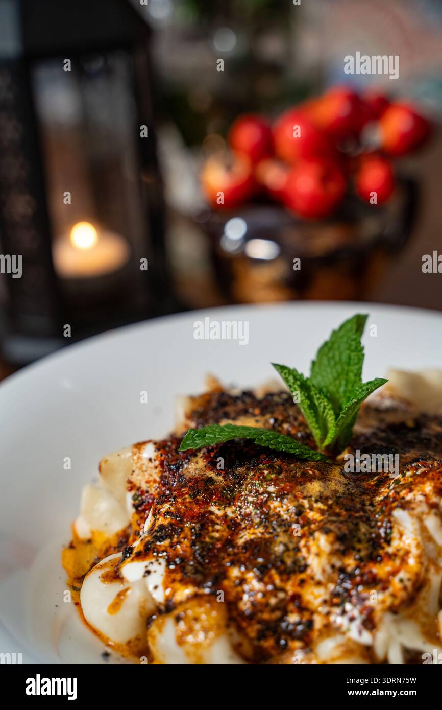 Close up of manti Turkish dumpling with yogurt and sauce Stock Photo ...