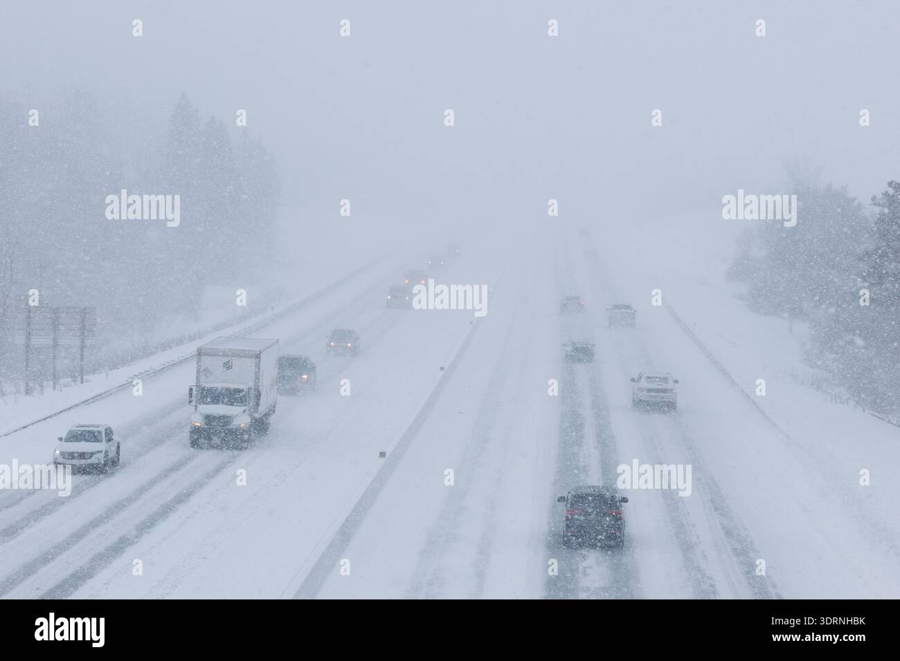 Vehicles travel along snow covered highway 400 as a heavy winter storm ...