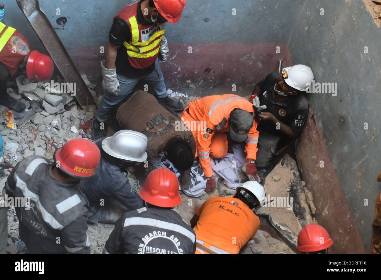 Rescue workers recover a body from the rubble following a gas explosion ...