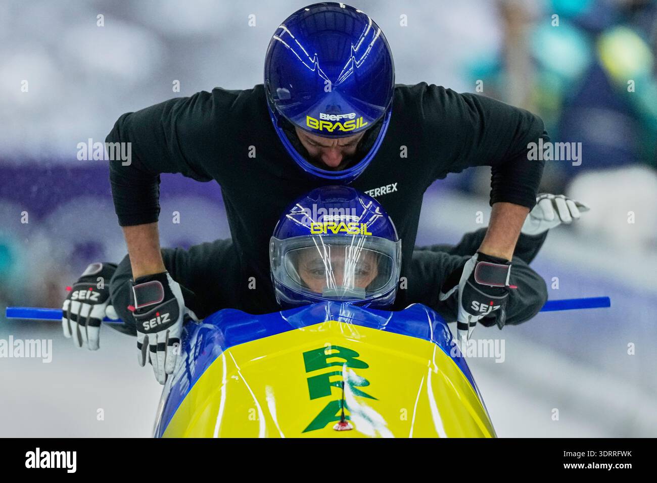 Brazil's Edson Luques Bindilatti, front, starts for a four man bobsled ...