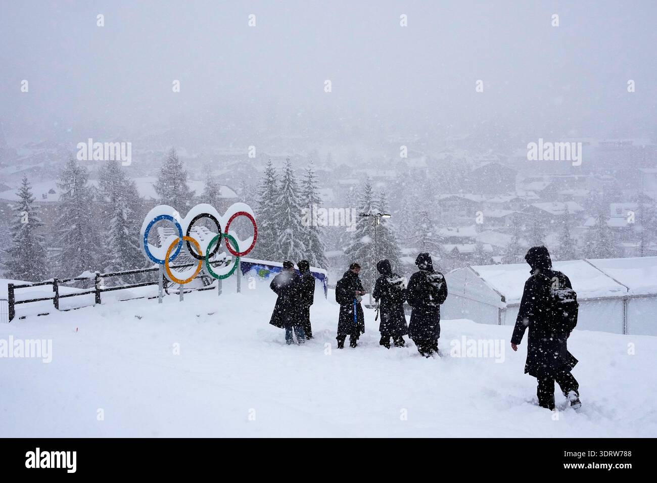 People walk past olympic rings at the sliding center during the 2026 ...