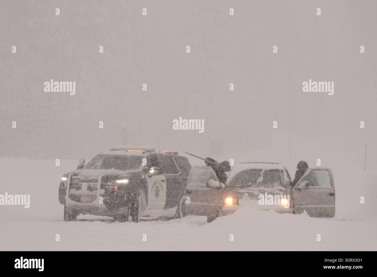 Motorists stuck in the snow are aided by a member of the California ...