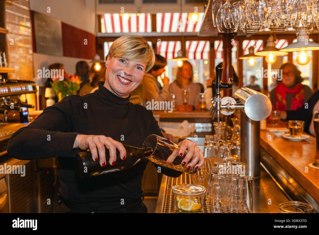 Cindy Holmberg hinter Theke mit Bier. Politik: Ricarda Langt schenkt ...