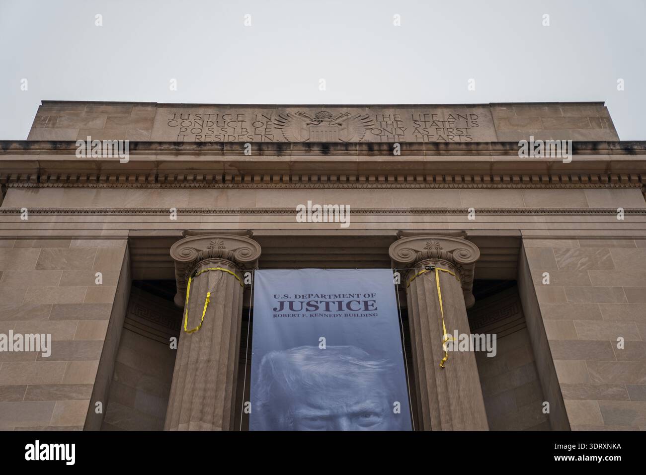 A banner showing President Donald Trump is hung from the Department of ...