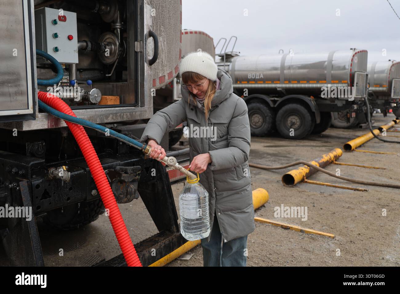A woman gets drinking water distributed by authorities in the city of ...
