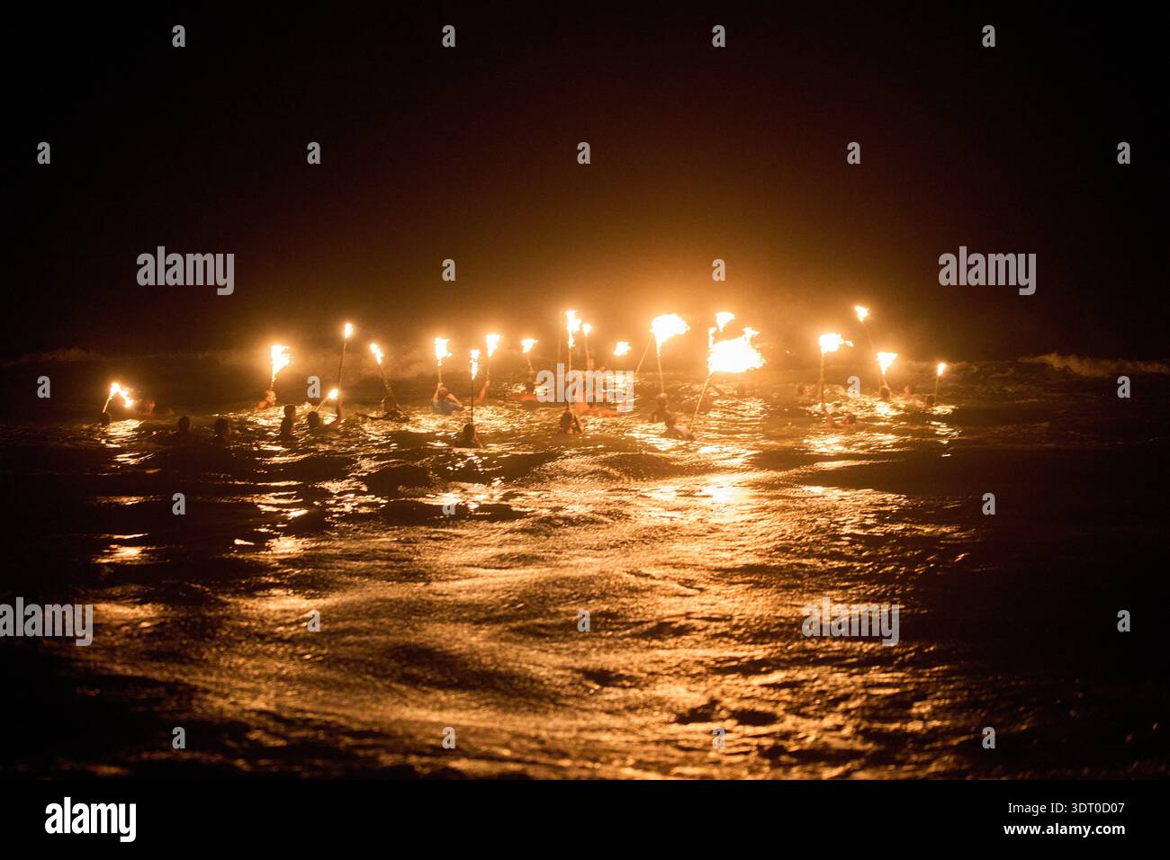 Lifeguards holding torches, wade into the Atlantic ocean in a ceremony ...