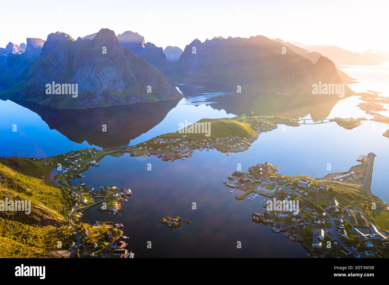 Aerial view of Norwegian fjord village with mountains at sunset ...