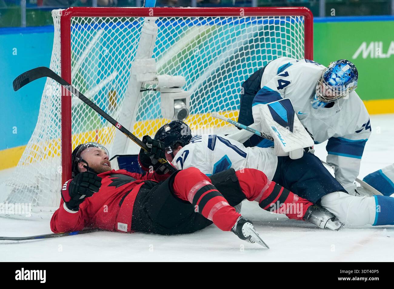Finland's Juuse Saros (74) attempts to block a shot by Canada's Sam ...